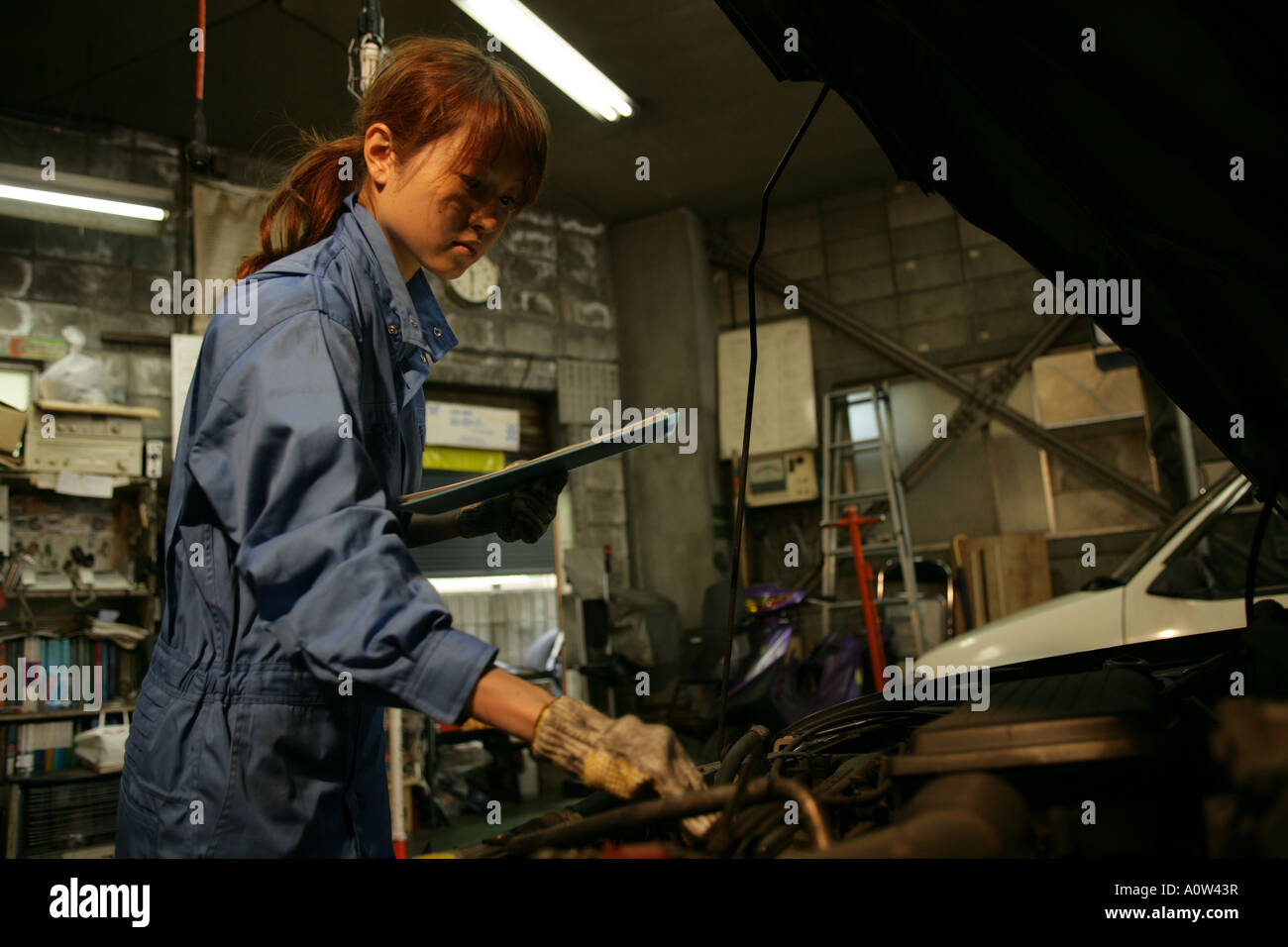Side profile of a female auto mechanic repairing an engine Stock Photo ...