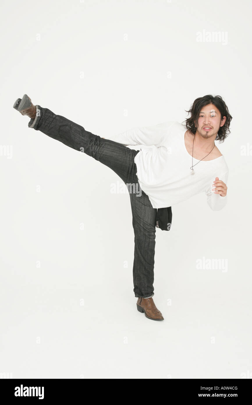 Portrait of a young man kicking and smiling Stock Photo - Alamy