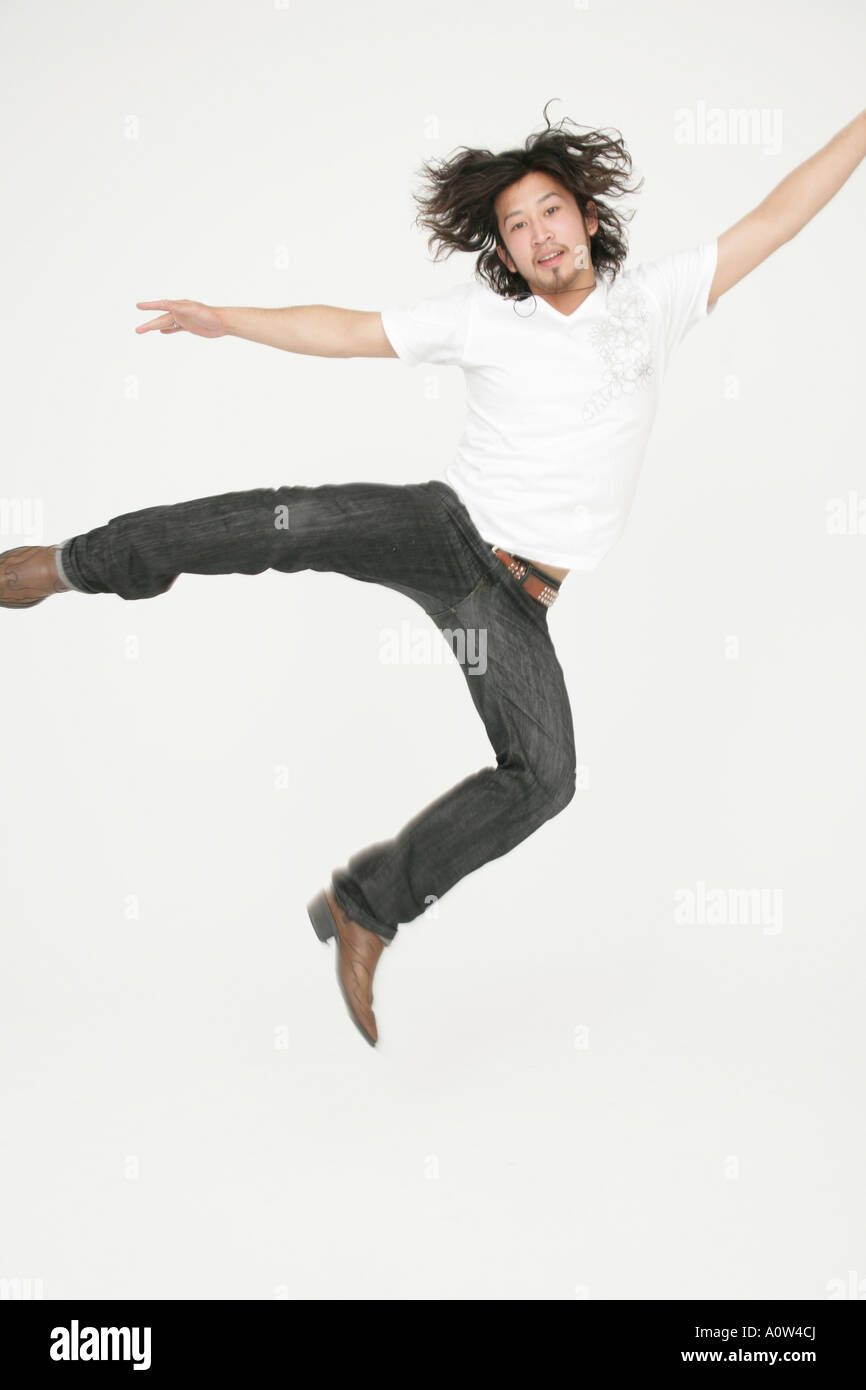 Portrait of a young man jumping with his arms outstretched Stock Photo ...