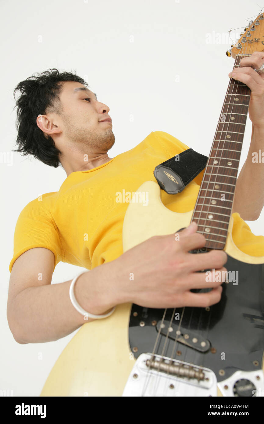 Low angle view of a young man playing an electric guitar Stock Photo ...