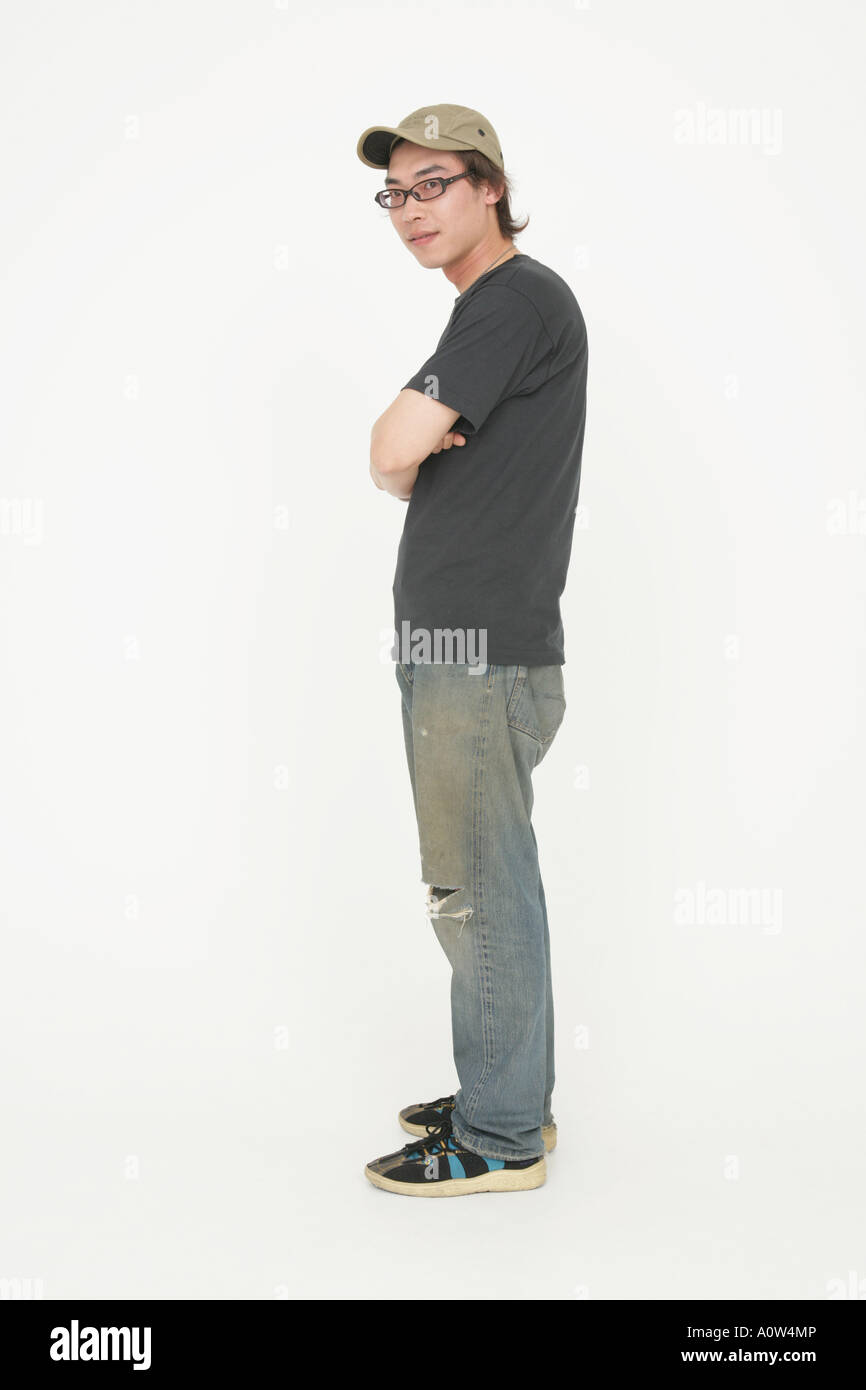 Side profile of a young man standing with his arms crossed Stock Photo ...