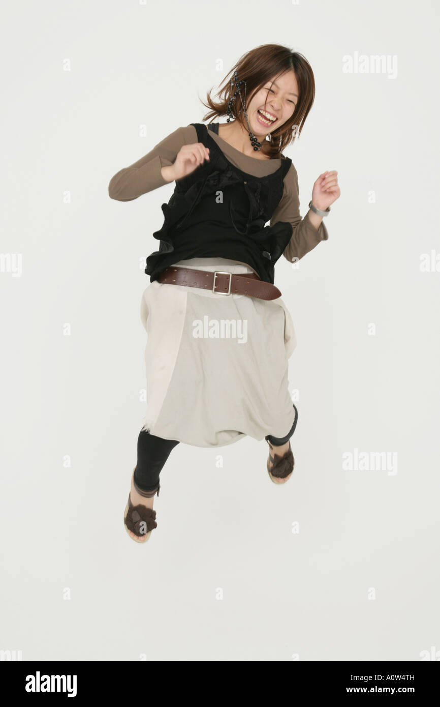 Young woman jumping and laughing Stock Photo - Alamy