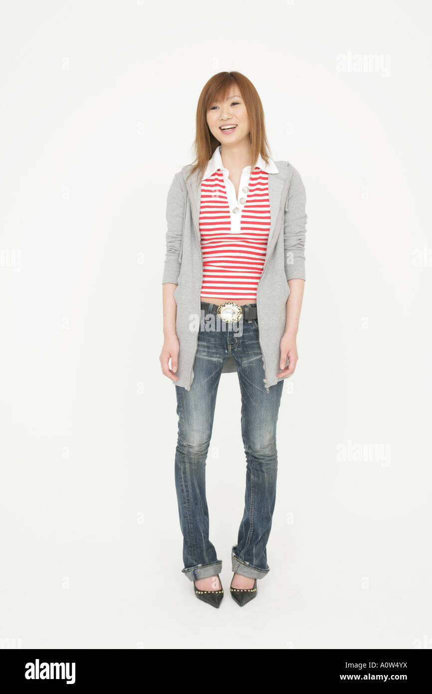Young woman standing and smiling Stock Photo - Alamy