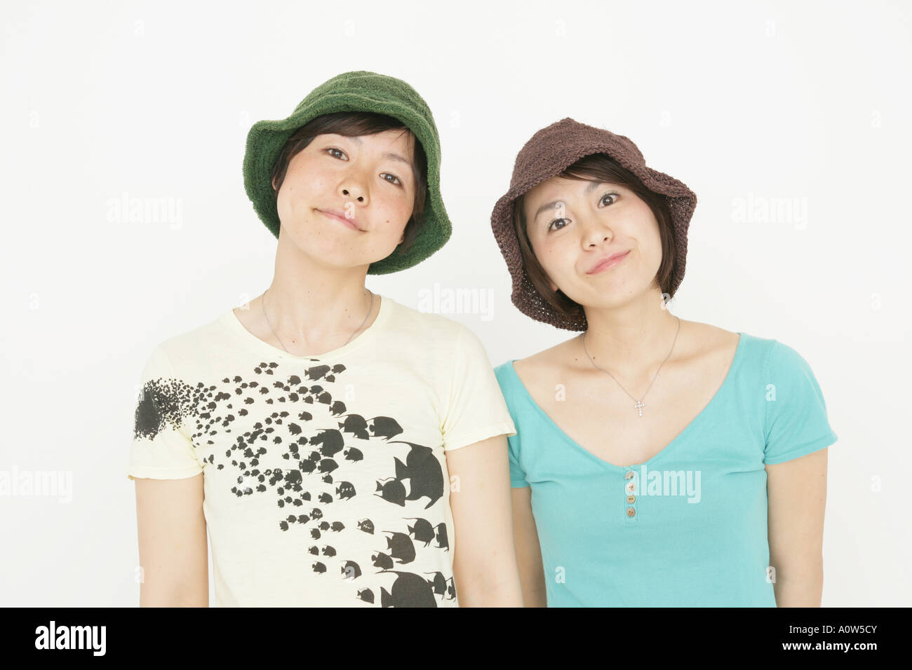 Portrait of two young women smirking Stock Photo - Alamy