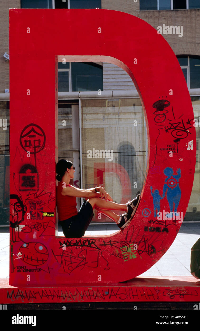 A woman sitting in a big letter D outisde the museum of modern art in ...
