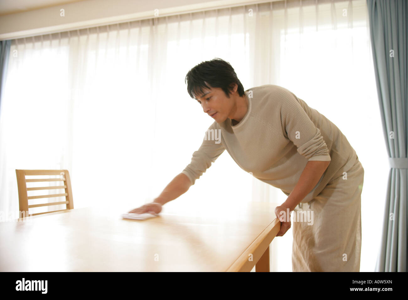 Mid adult man cleaning the table Stock Photo - Alamy