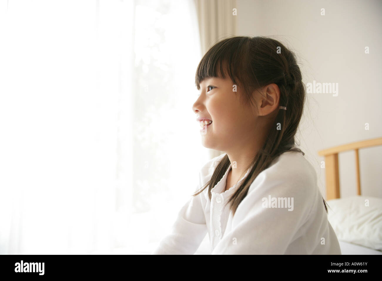 Side profile of a girl lying on the bed and smiling Stock Photo - Alamy