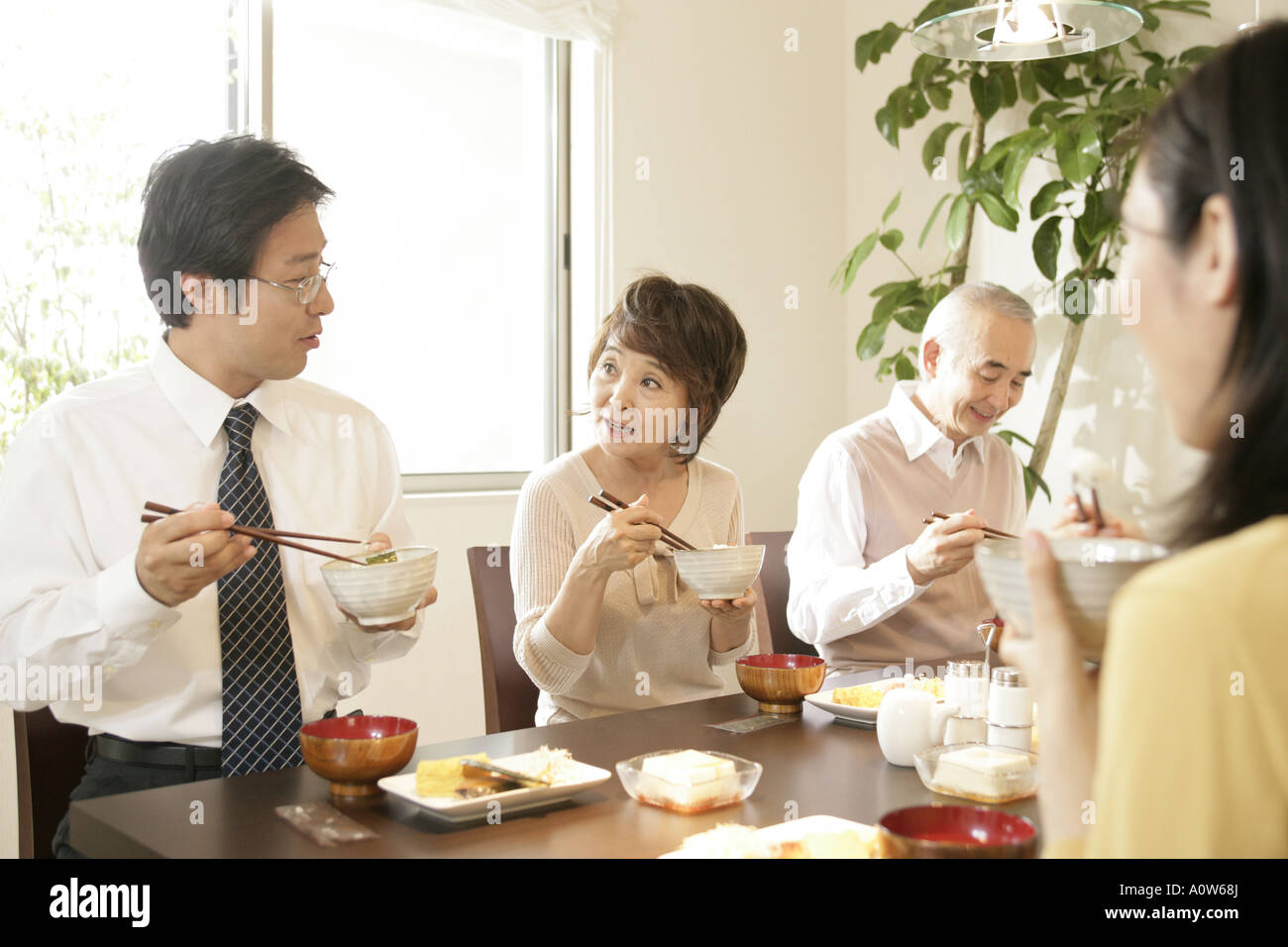 Family sitting at the dining table Stock Photo - Alamy