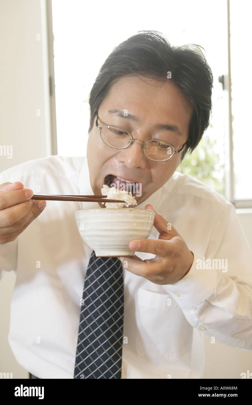 Close up of a mid adult man eating rice Stock Photo - Alamy