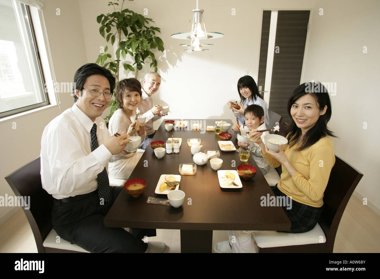 Family sitting around the dining table Stock Photo - Alamy