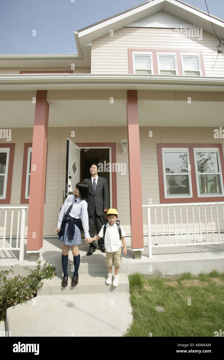 Mature man stepping out of the house with his son and daughter Stock ...