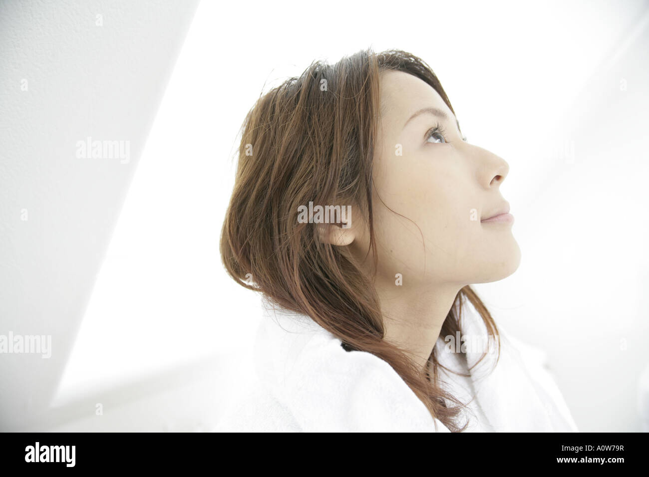 Side profile of a young woman looking into a mirror Stock Photo - Alamy