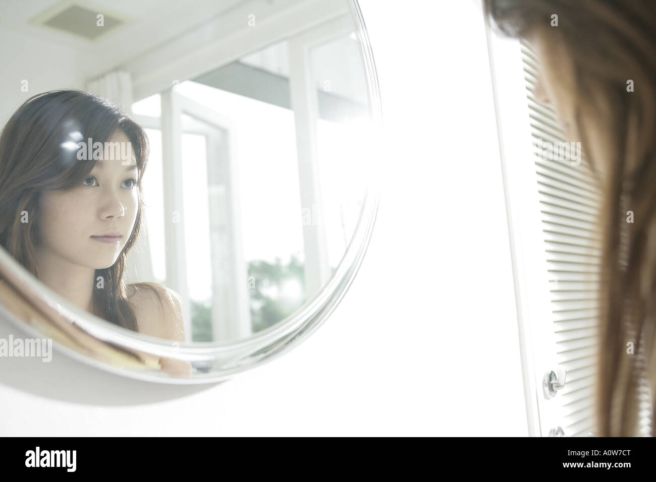 Reflection of a young woman in a mirror Stock Photo - Alamy