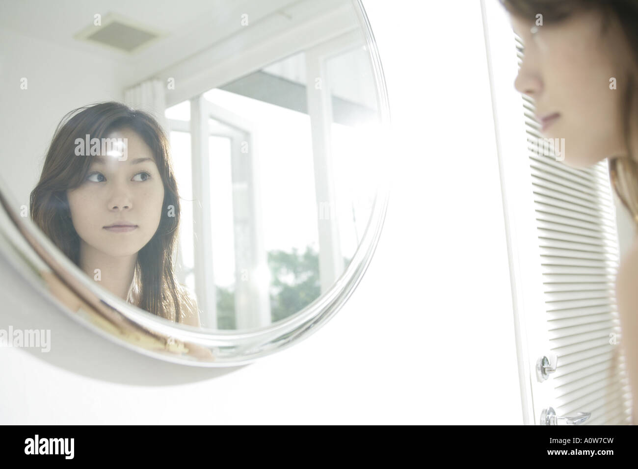 Reflection of a young woman in a mirror Stock Photo - Alamy