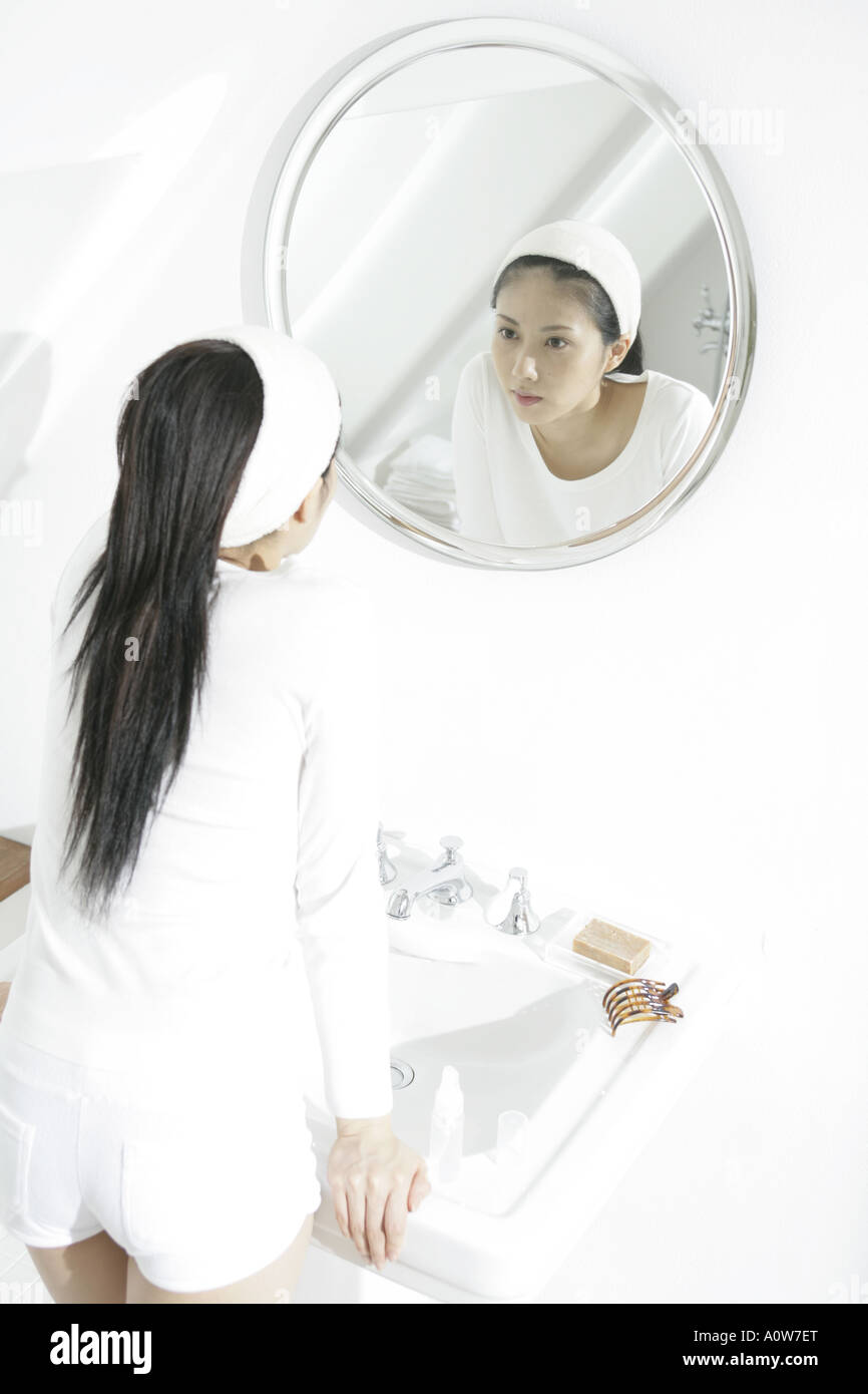 Rear view of a young woman looking in a mirror Stock Photo - Alamy