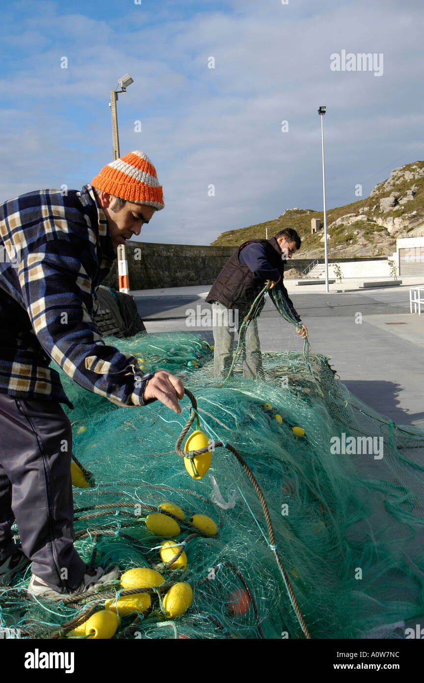 Fisherman fixing nets at port of Corme in Death Coast Galicia Spain ...