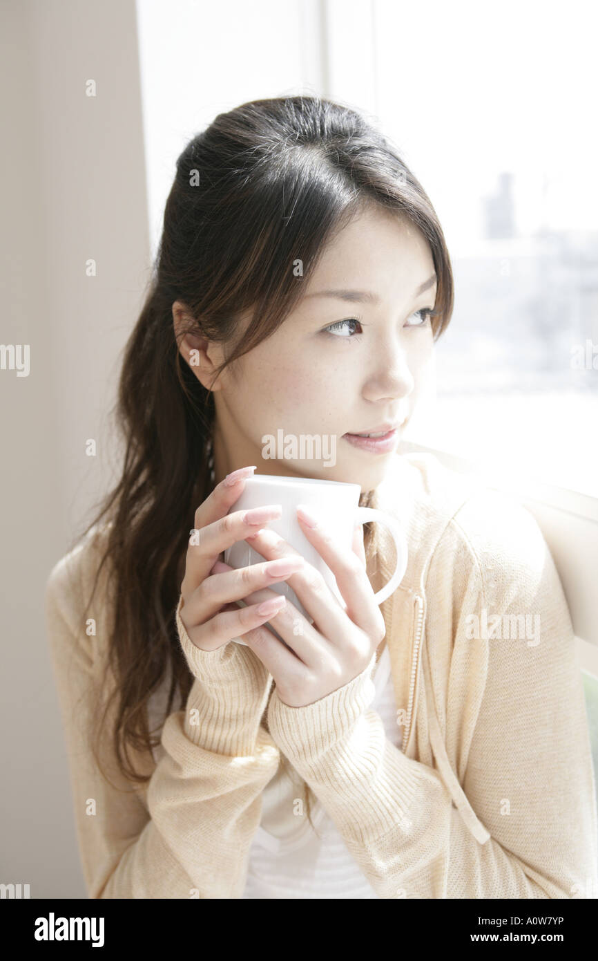 Close up of a young woman holding a mug Stock Photo - Alamy