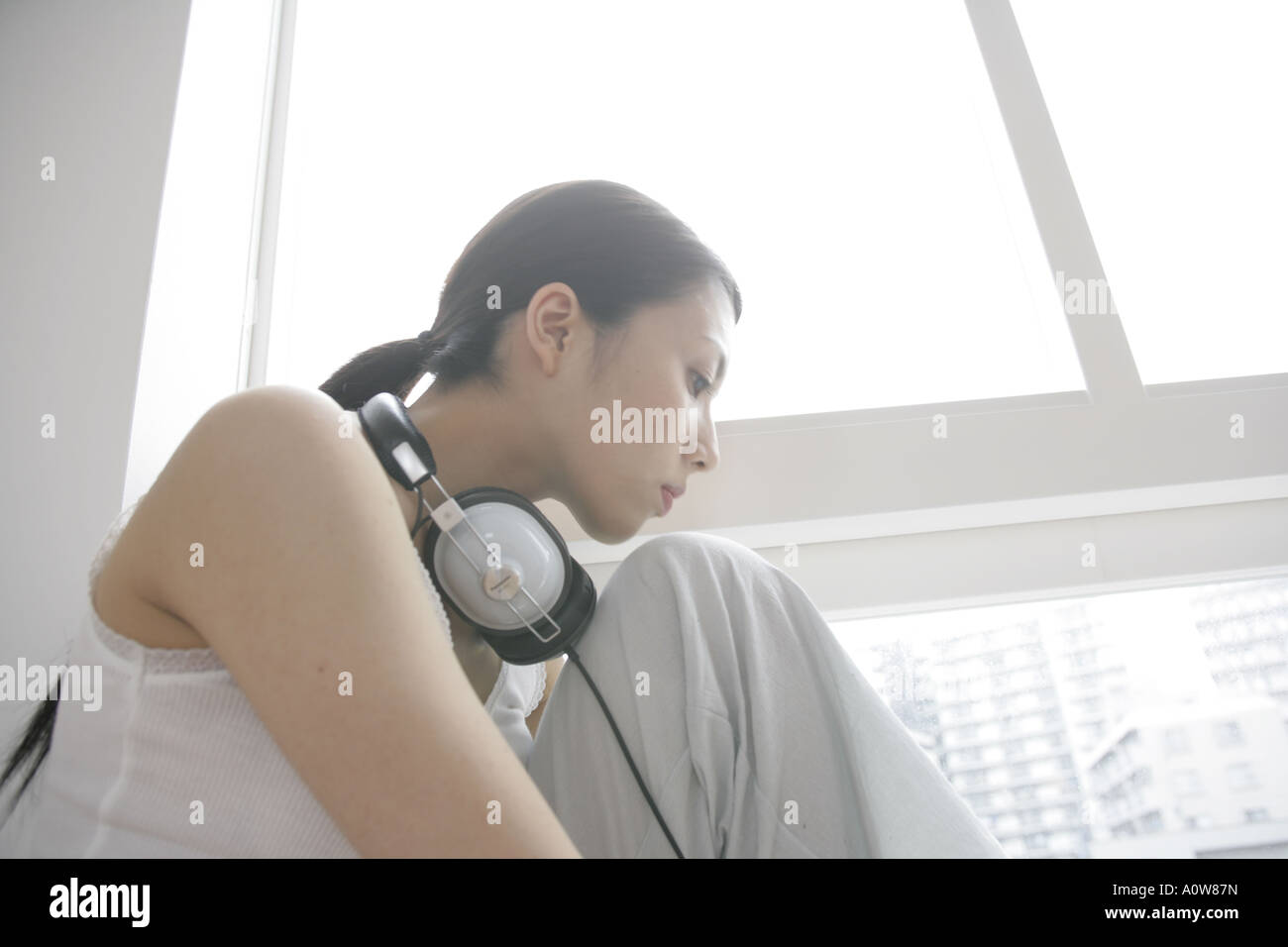 Side profile of a young woman sitting beside a window Stock Photo - Alamy