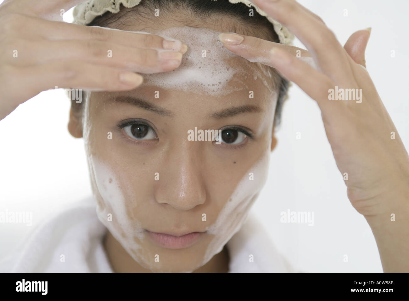 Portrait of a young woman applying soap on her forehead Stock Photo - Alamy