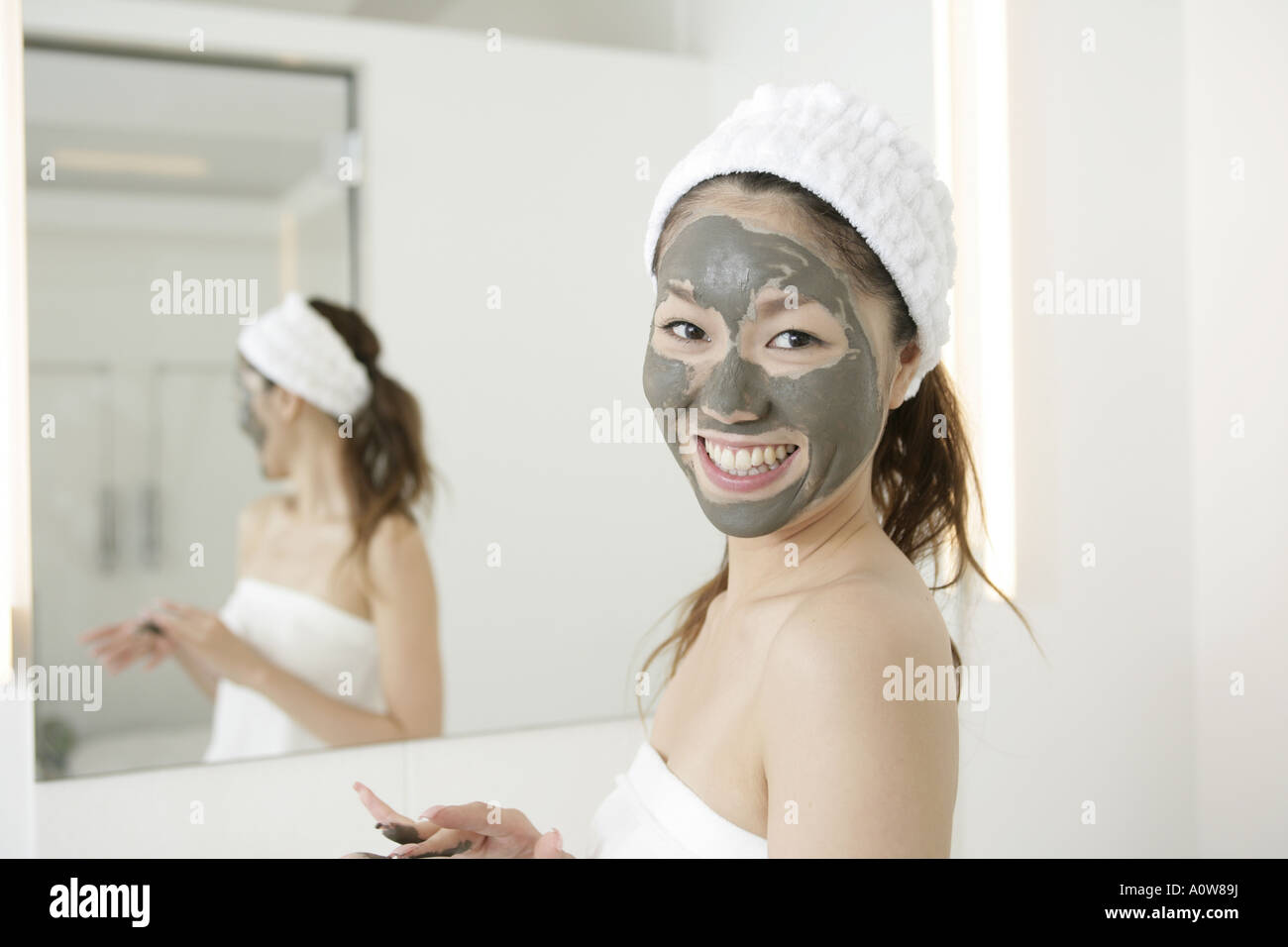 Portrait of a young woman smiling with a facial mask Stock Photo - Alamy
