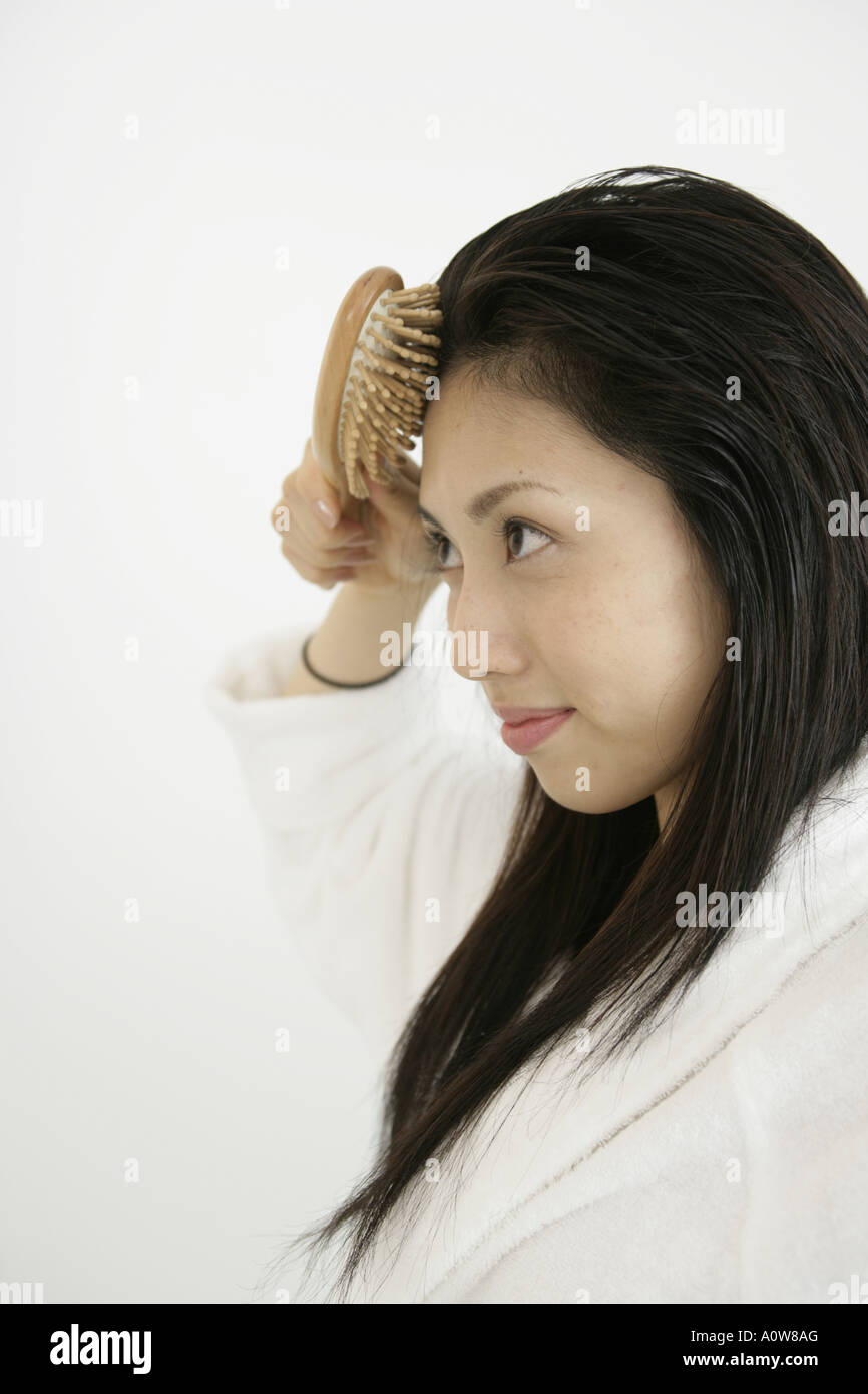 Side profile of a young woman brushing her hair Stock Photo - Alamy