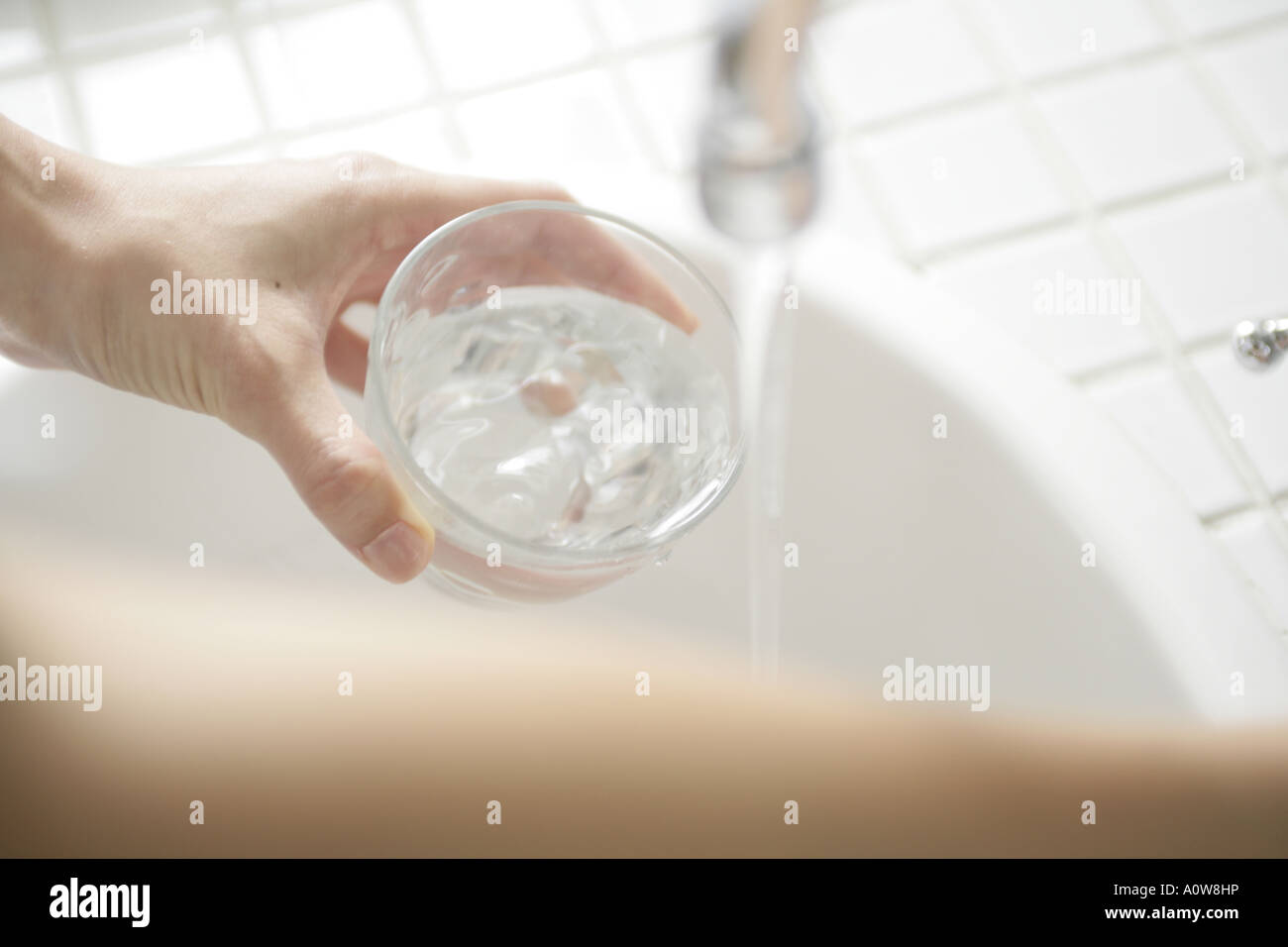 High angle view of a woman s hand filling water into a glass from a ...