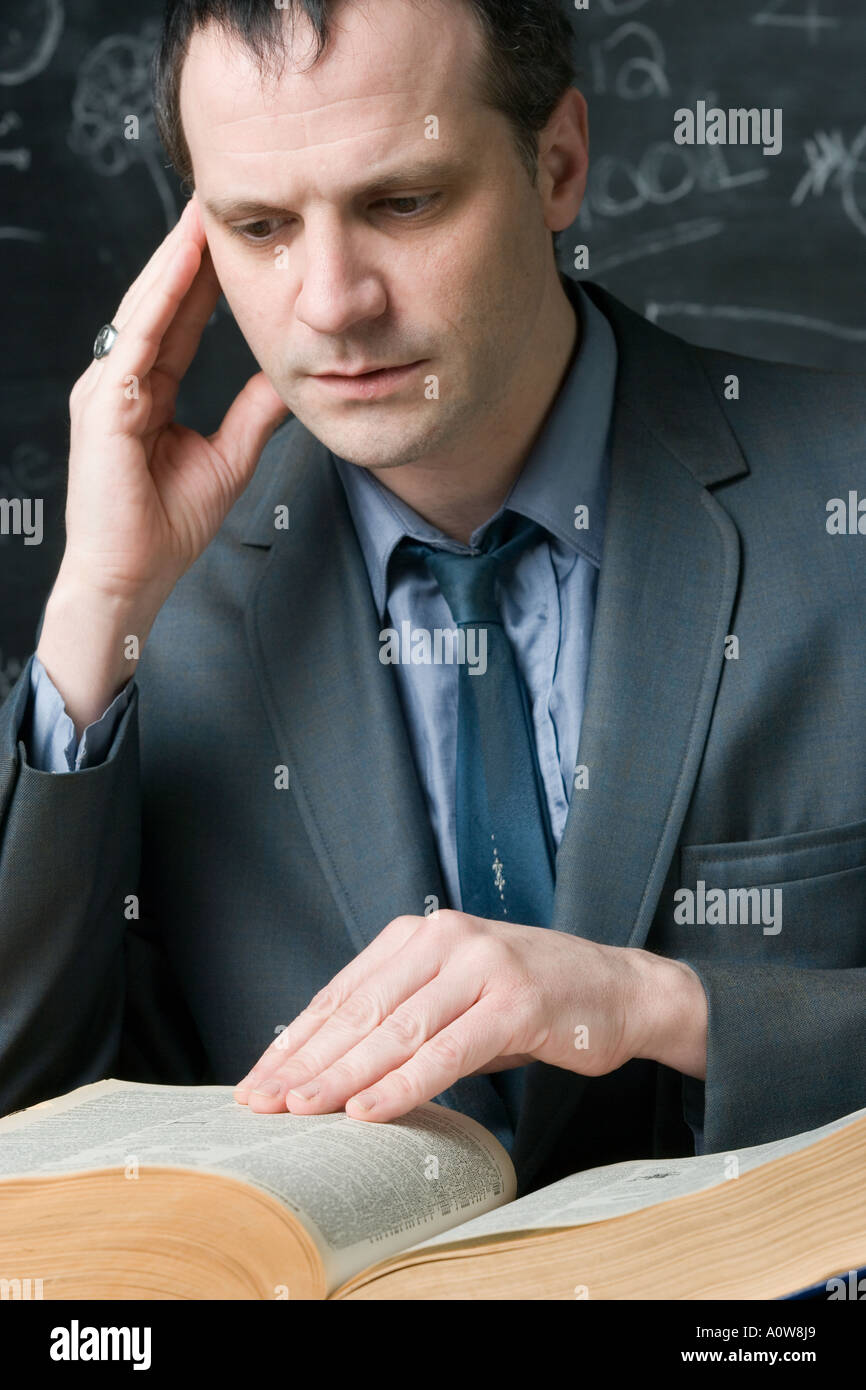 Portrait Caucasian teacher sitting at desk Stock Photo - Alamy