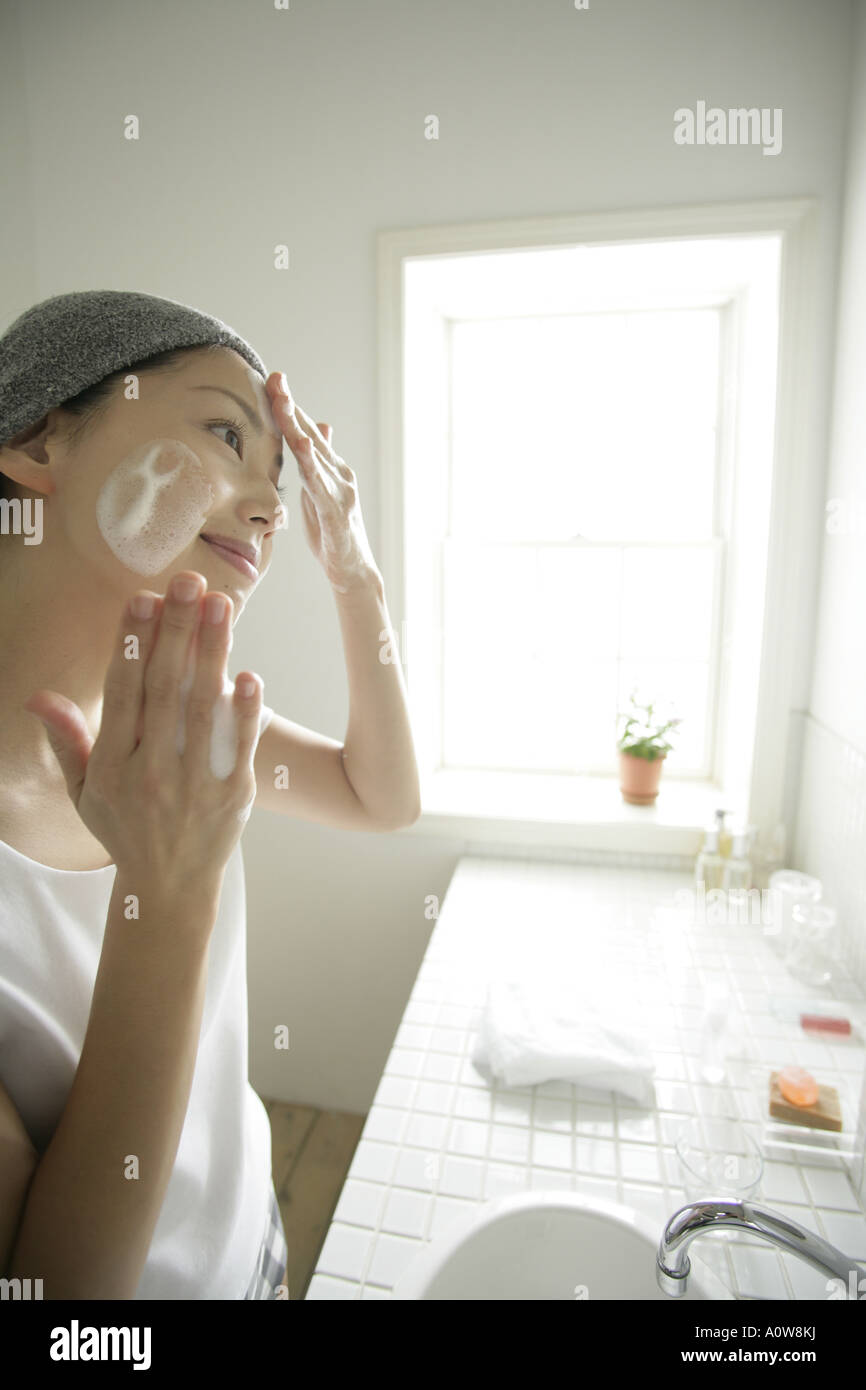 Side profile of a young woman applying soap on her face Stock Photo - Alamy