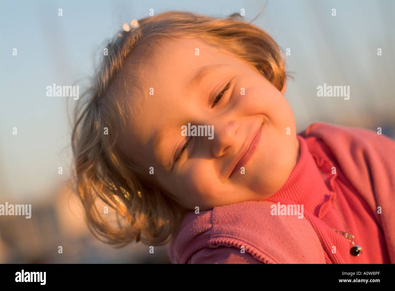 Portrait of a smiling little girl at sunset, France Stock Photo - Alamy