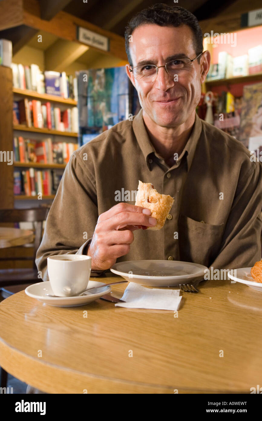 Portrait of man eating pastry Stock Photo - Alamy