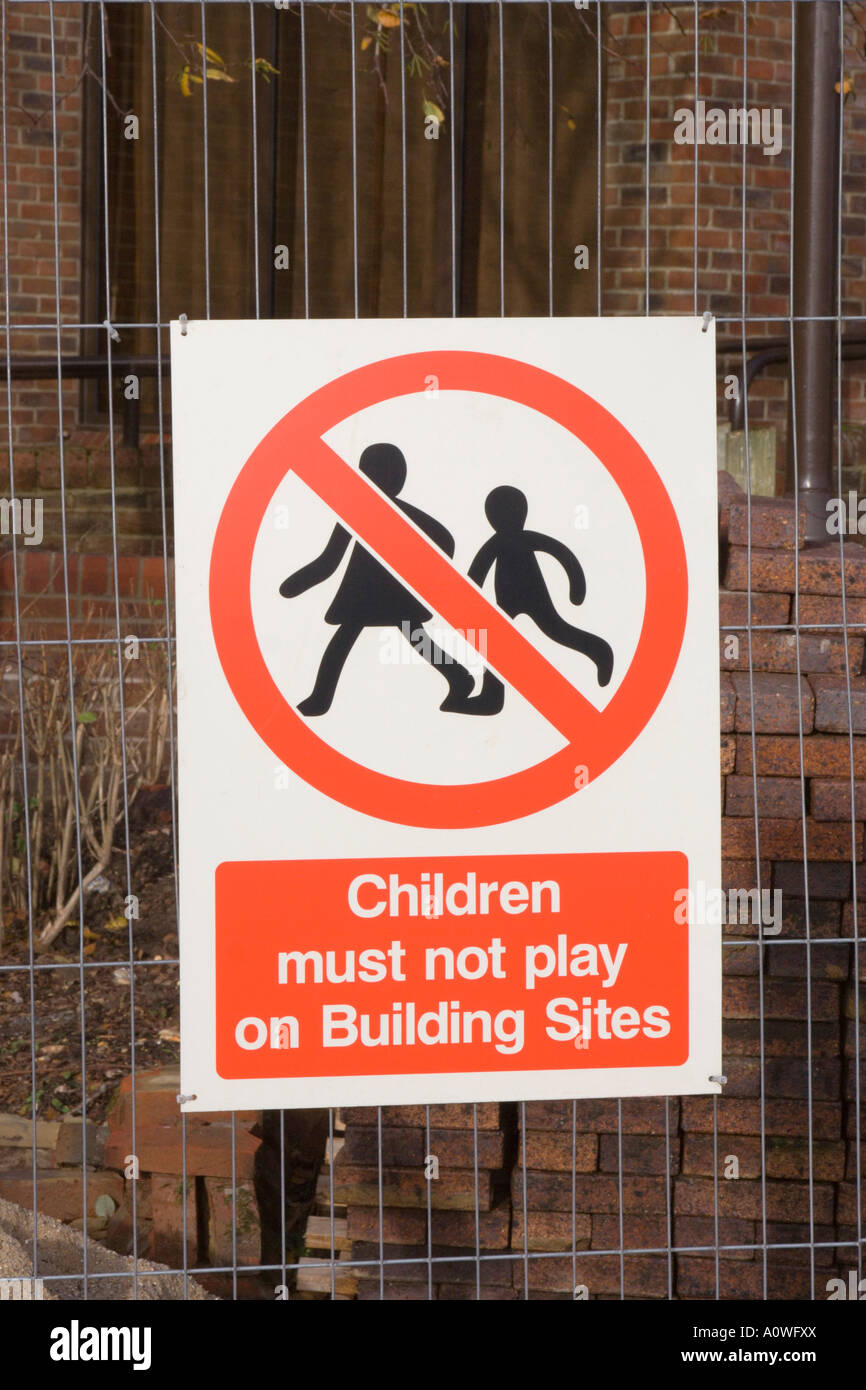 A warning sign on wire fence. Building site notice. Children must not ...