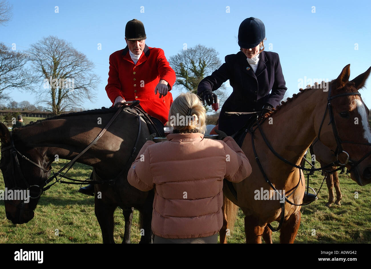 Riders on horse back have a drink at a start of a fox hunt in West ...