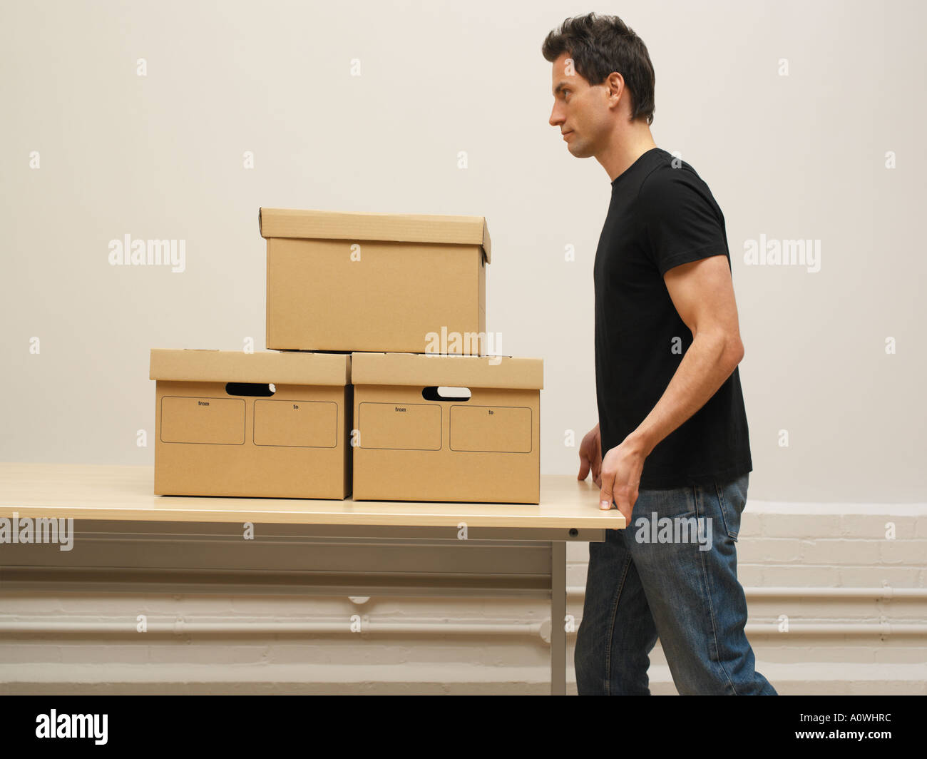 Man moving a desk and boxes Stock Photo - Alamy