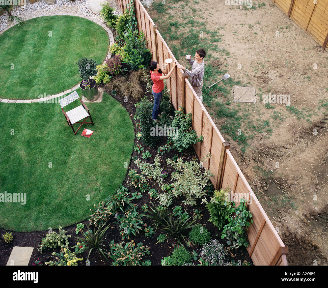 Neighbours talking over fence hi-res stock photography and images - Alamy