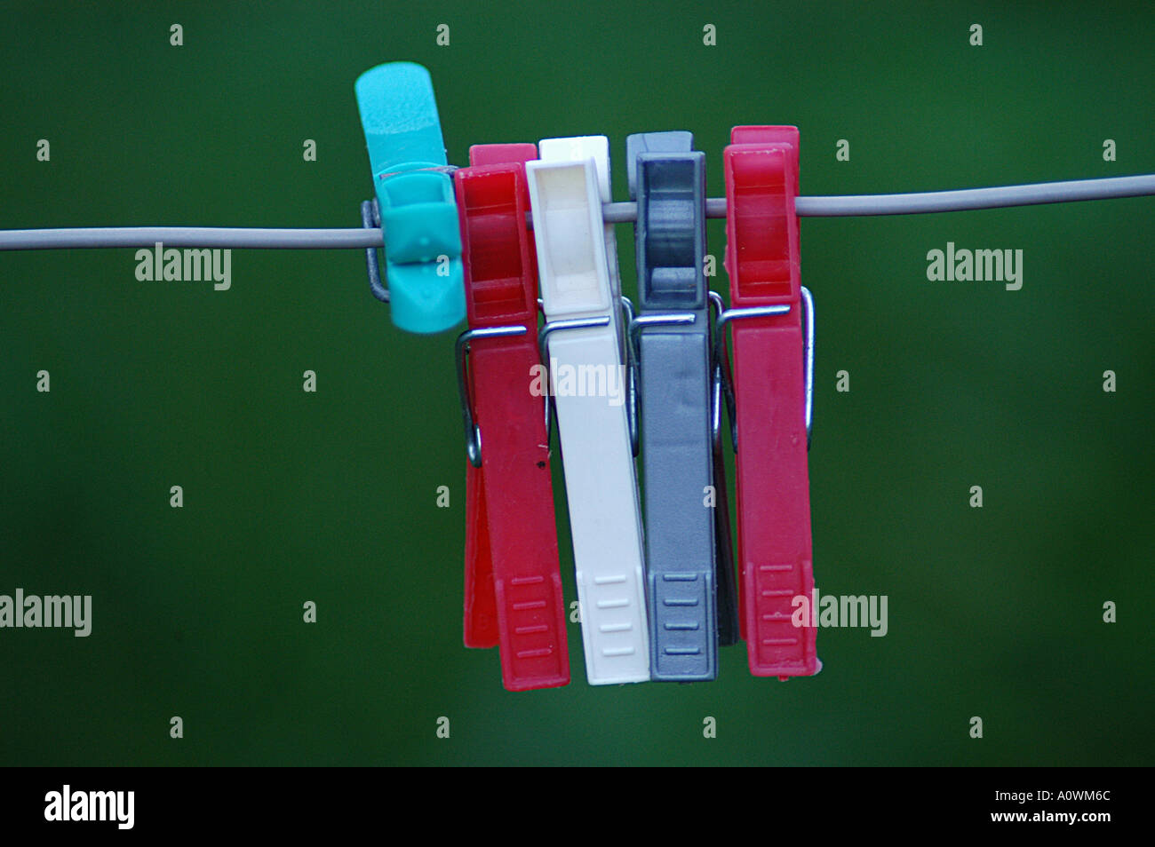 coloured solid plastic clothes pegs on washing line Stock Photo - Alamy