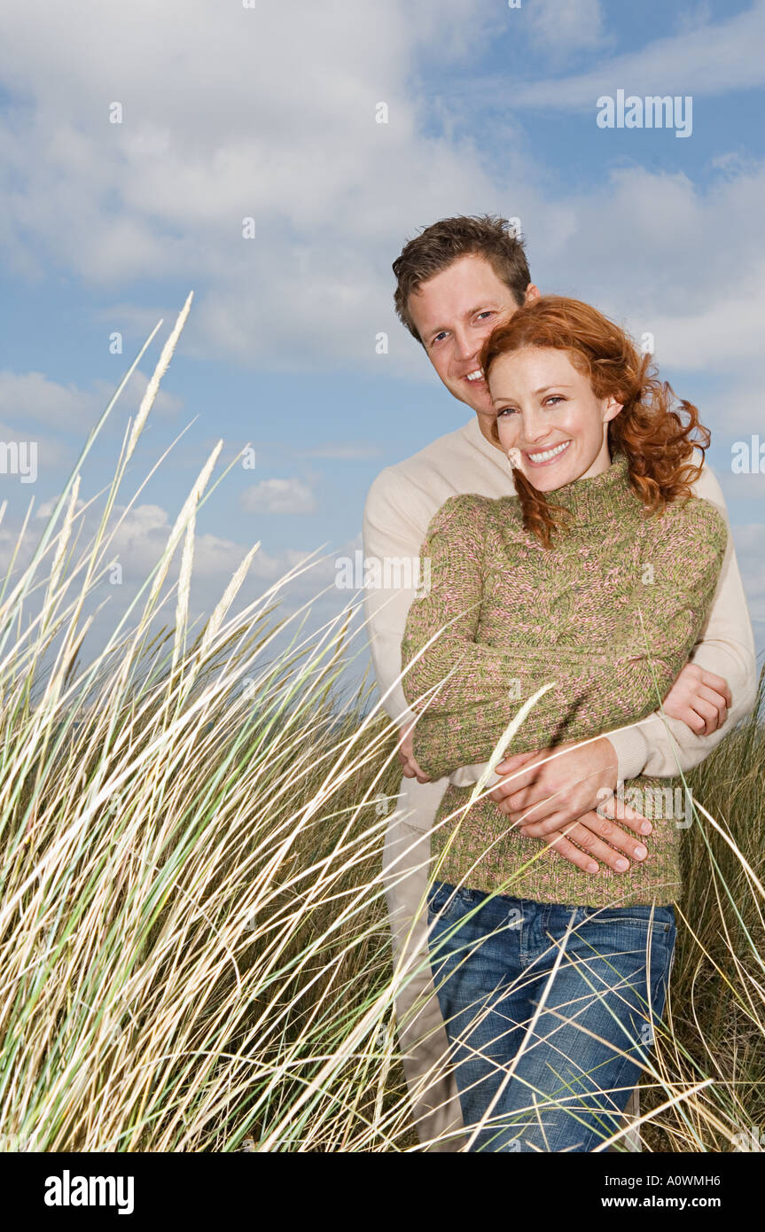 Couple hugging in a field Stock Photo - Alamy