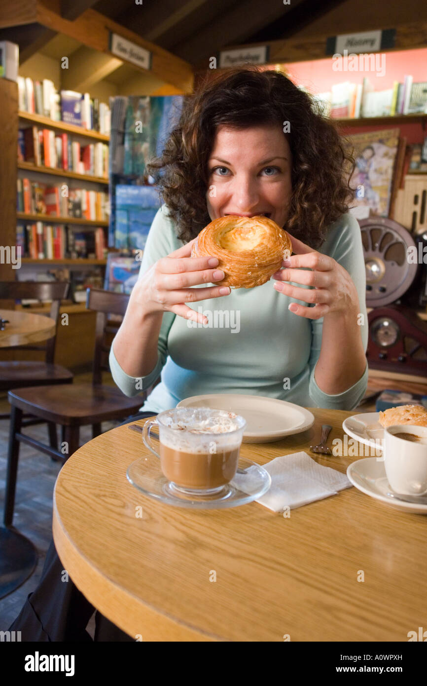 Woman enjoying a pastry Stock Photo - Alamy