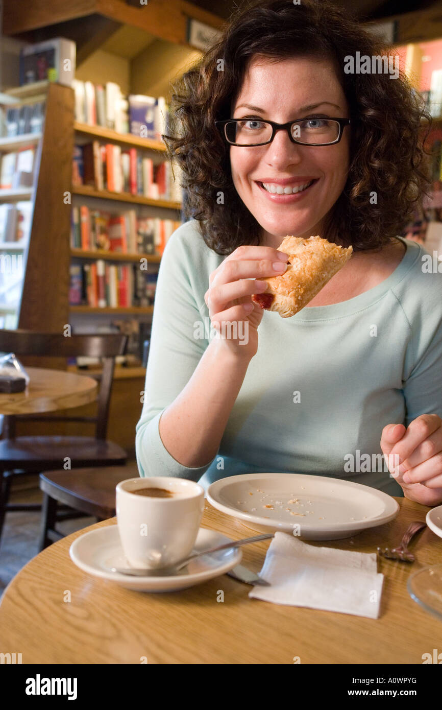 Woman enjoying a pastry Stock Photo - Alamy