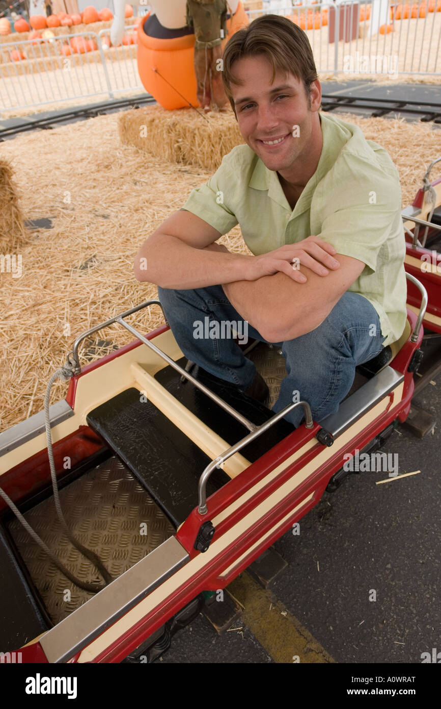 Adult man on mini train Stock Photo - Alamy