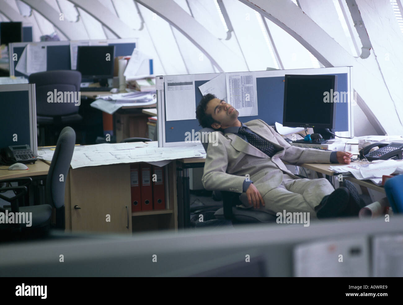 Office life and interiors. Office worker asleep at his desk Stock Photo ...