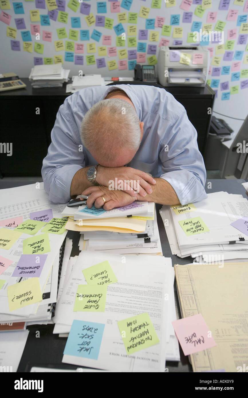 overworked office worker executive ponders at paperwork and workload ...