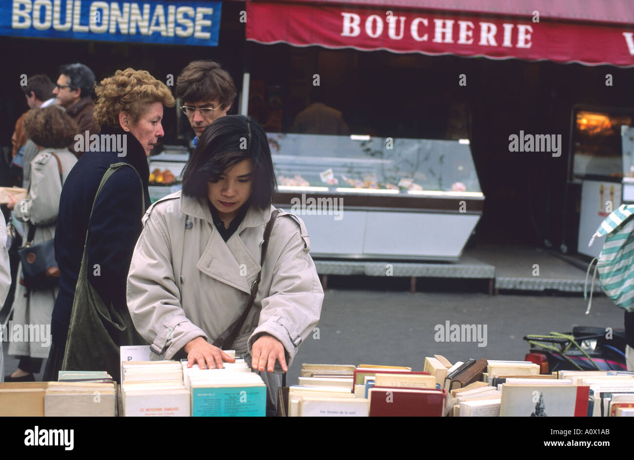 Woman looking through books at an outdoor market in Paris France Stock ...
