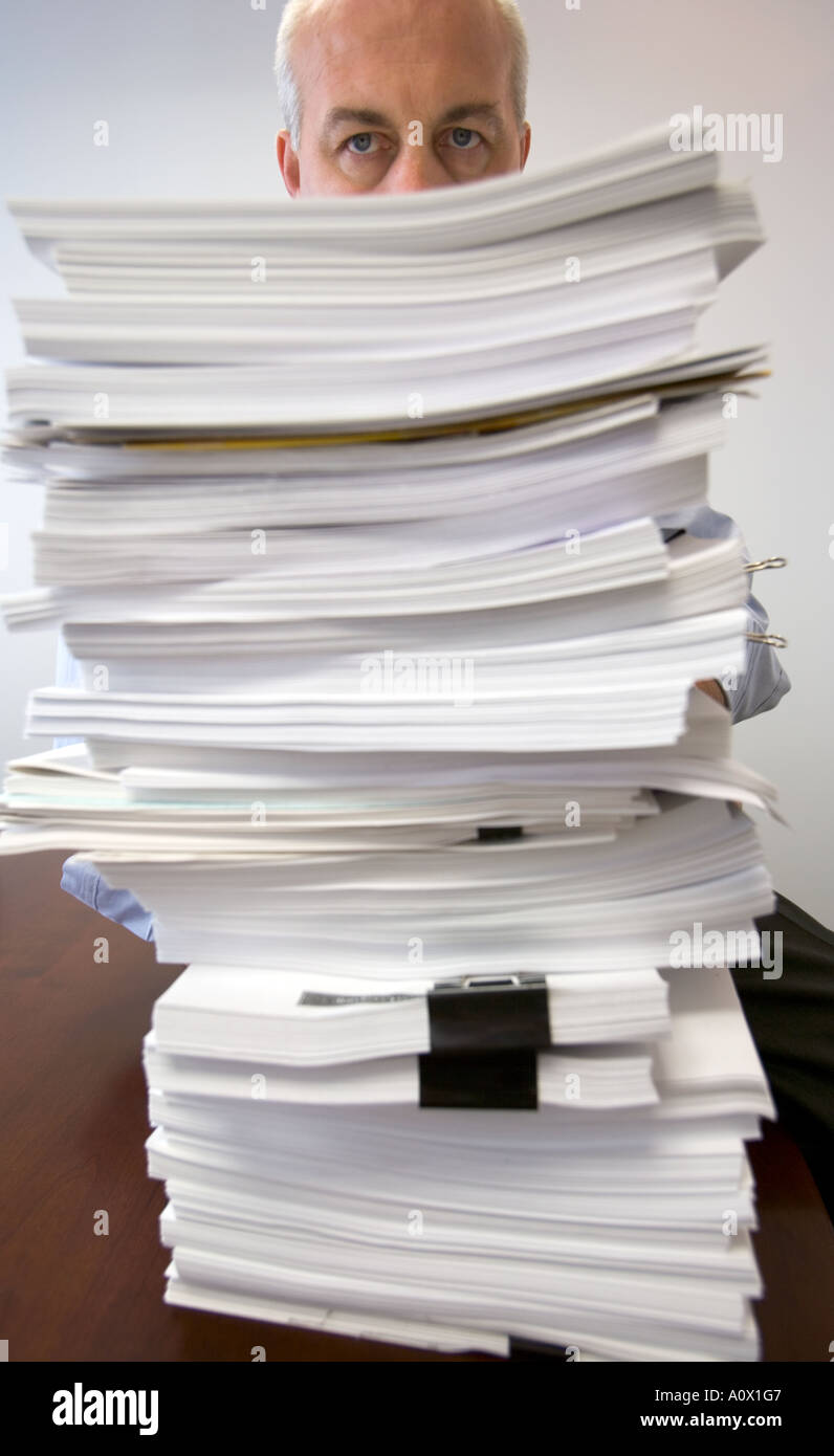 office worker executive ponders over stack of paperwork Stock Photo - Alamy