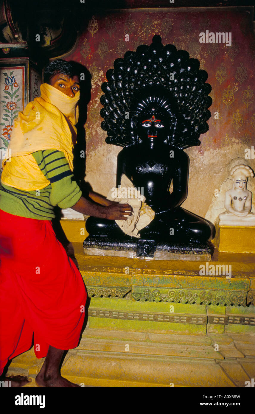 Jain priest cleaning a Jain statue Jaisalmer Rajasthan state India Asia ...