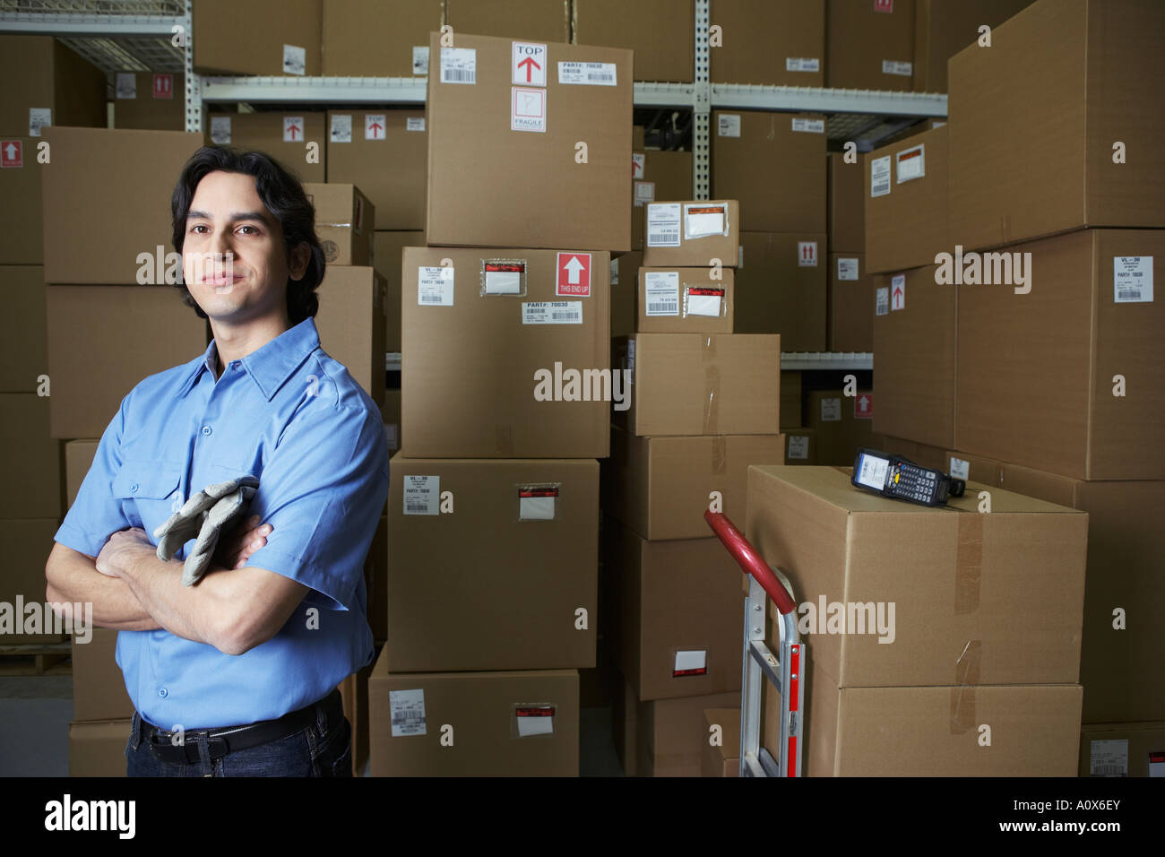 Hispanic male warehouse worker with boxes Stock Photo - Alamy