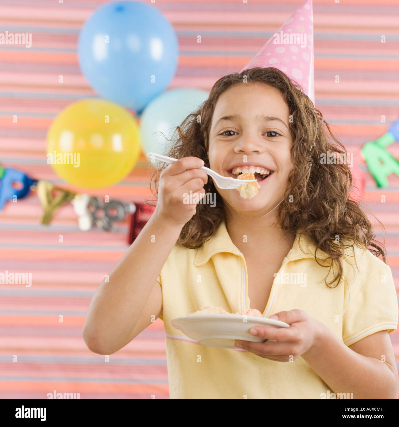 Young girl eating cake at birthday party Stock Photo - Alamy