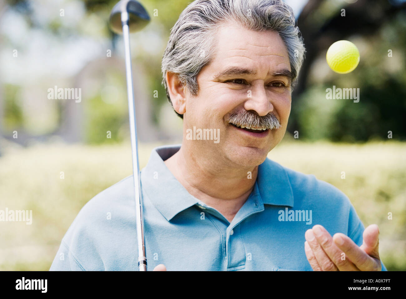 Middle aged man with golf club and golf ball Stock Photo - Alamy