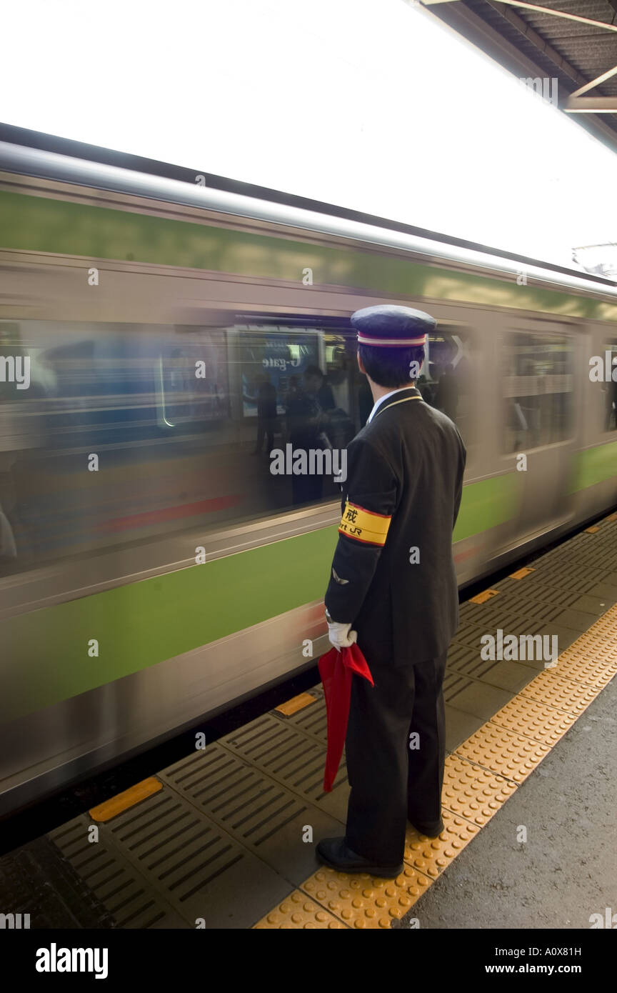 Platform conductor subway train at rush hour Shinjuku Tokyo Honshu ...