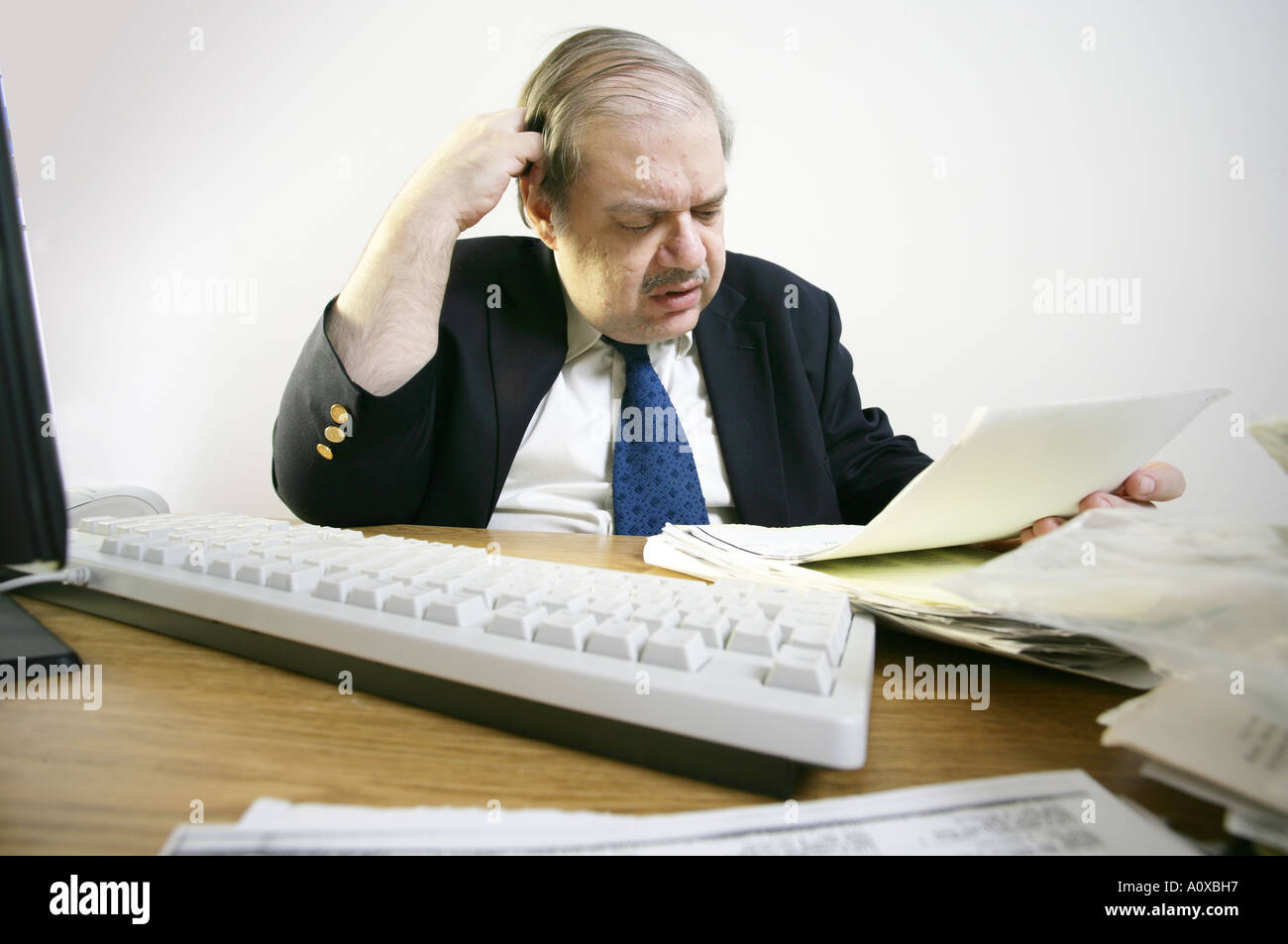 Business man is a bit frazzled, under pressure with an overload of work ...