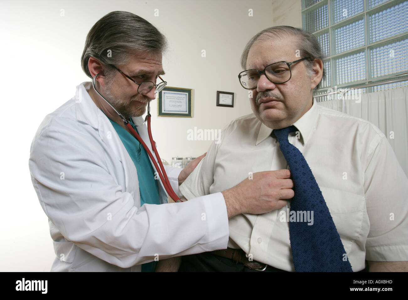 Doctor checks the heart rythym and sounds of the heart of a middle aged ...